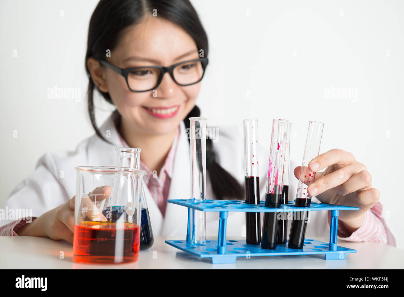 Asian lab people doing liquid sample analysis, on plain background ...