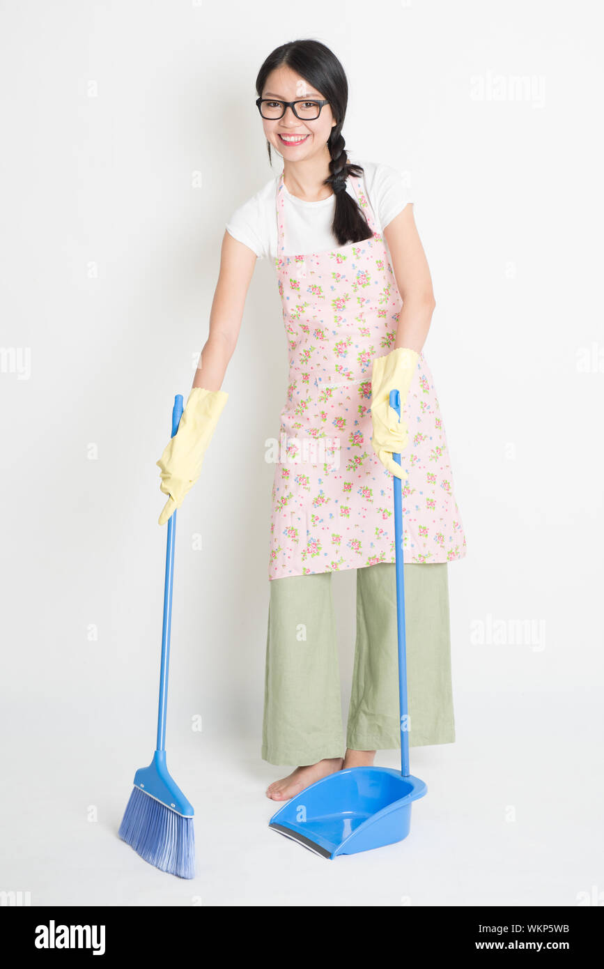 Full length Asian Chinese female housekeeping, sweeping floor with ...