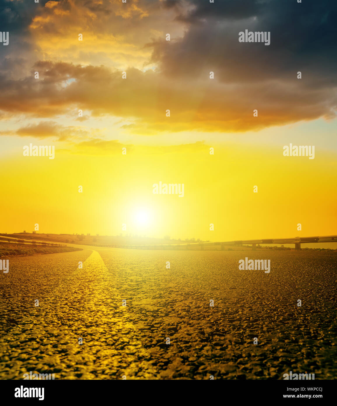 yellow sunset with dark clouds over asphalt road Stock Photo - Alamy