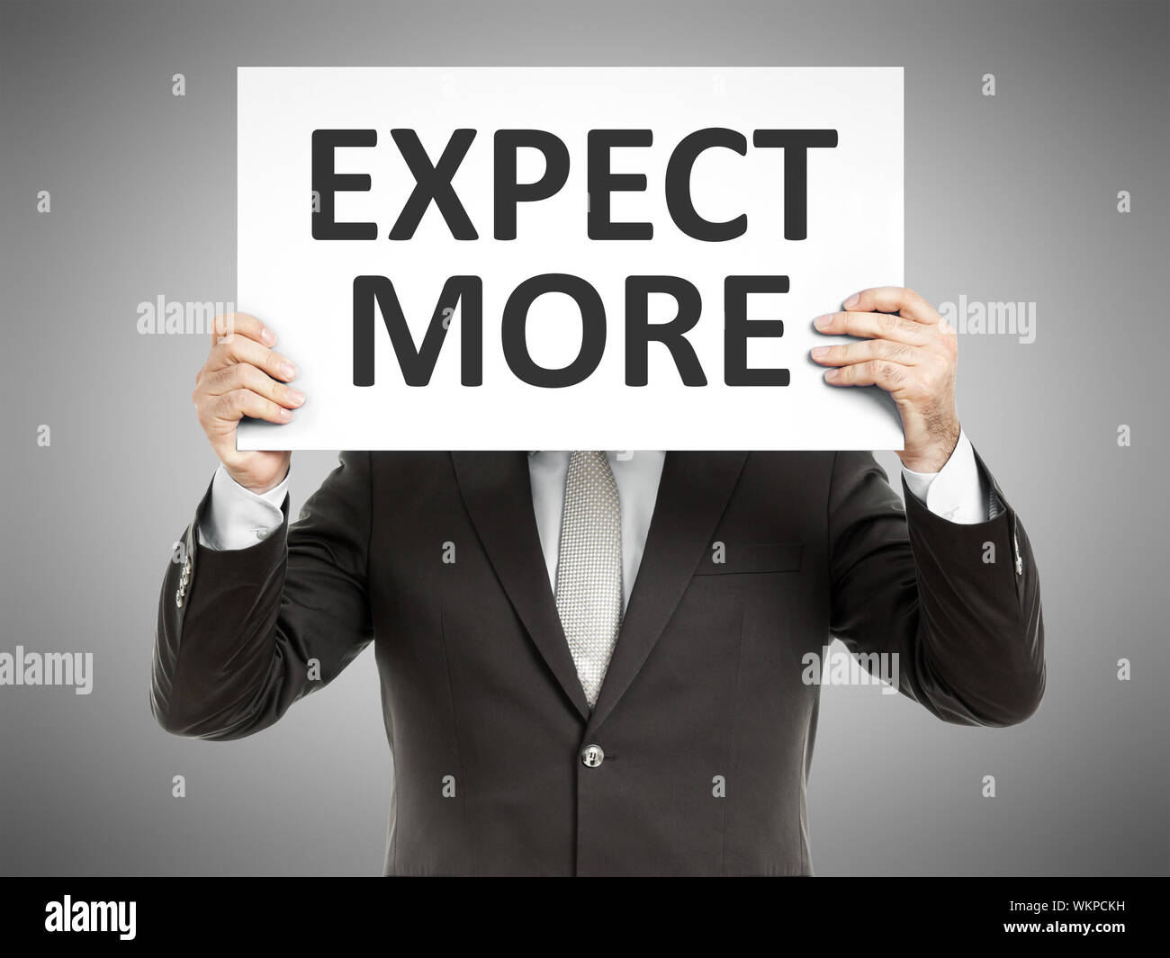 A business man holding a paper in front of his face with the text ...