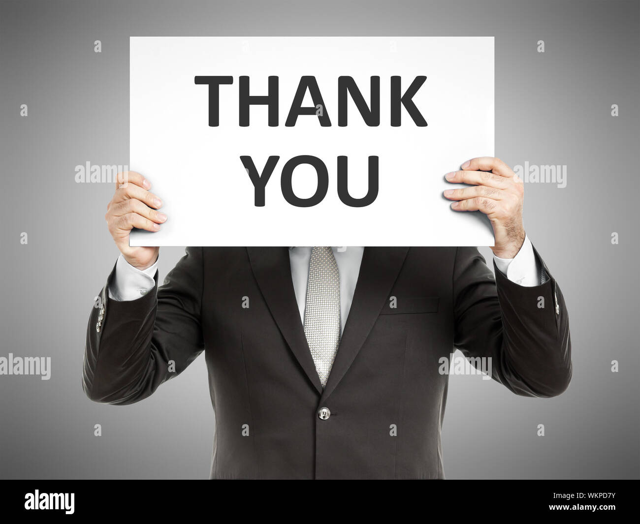 A business man holding a paper in front of his face with the text thank ...