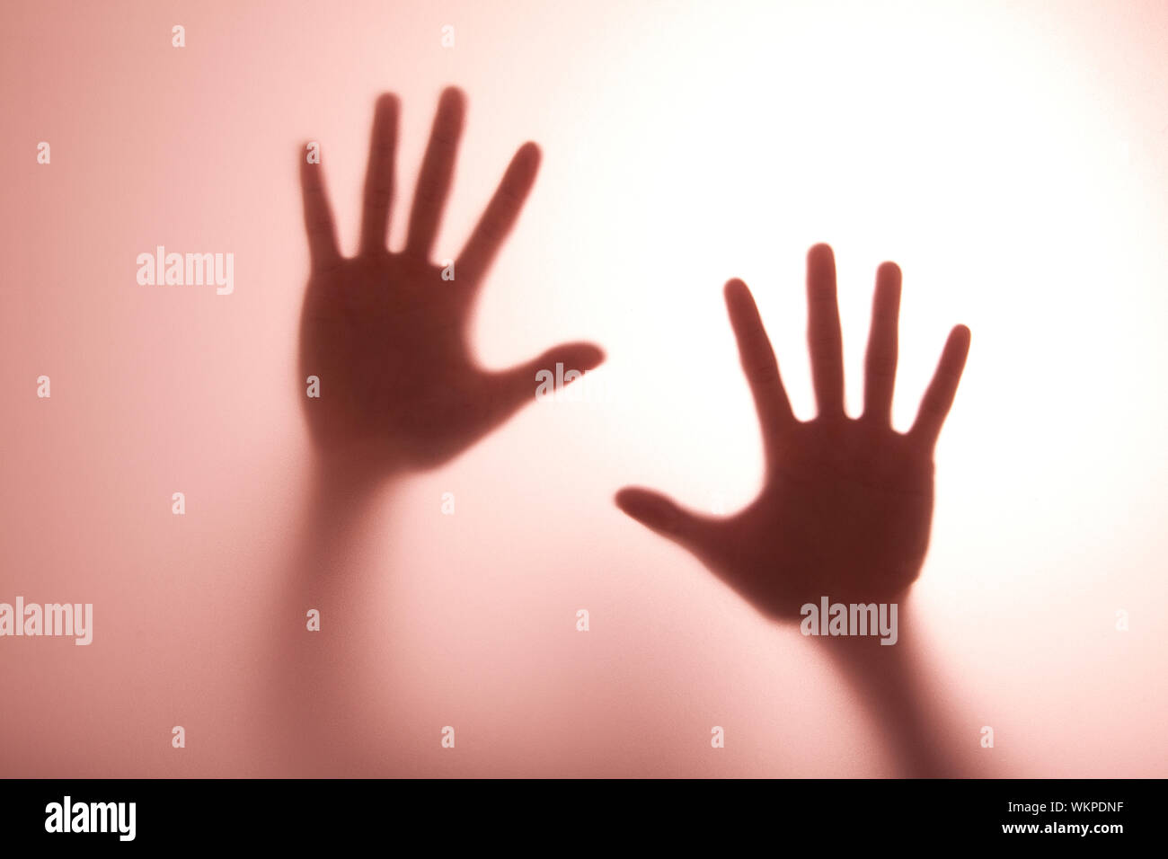 blurry hand reaching out and touching glass with Warm tone of light ...