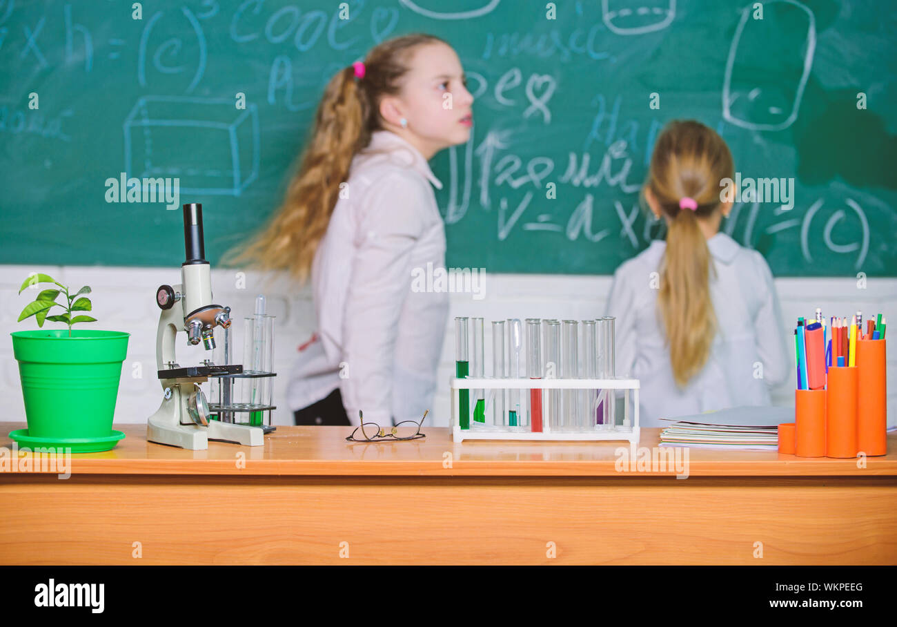 Microscope and test tubes on table in classroom. Kid near school ...