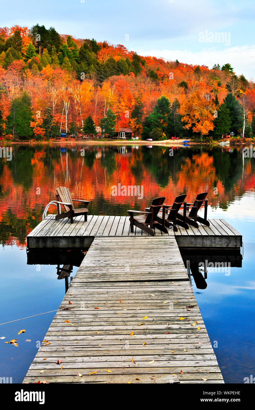 Wooden dock with chairs on calm fall lake Stock Photo - Alamy