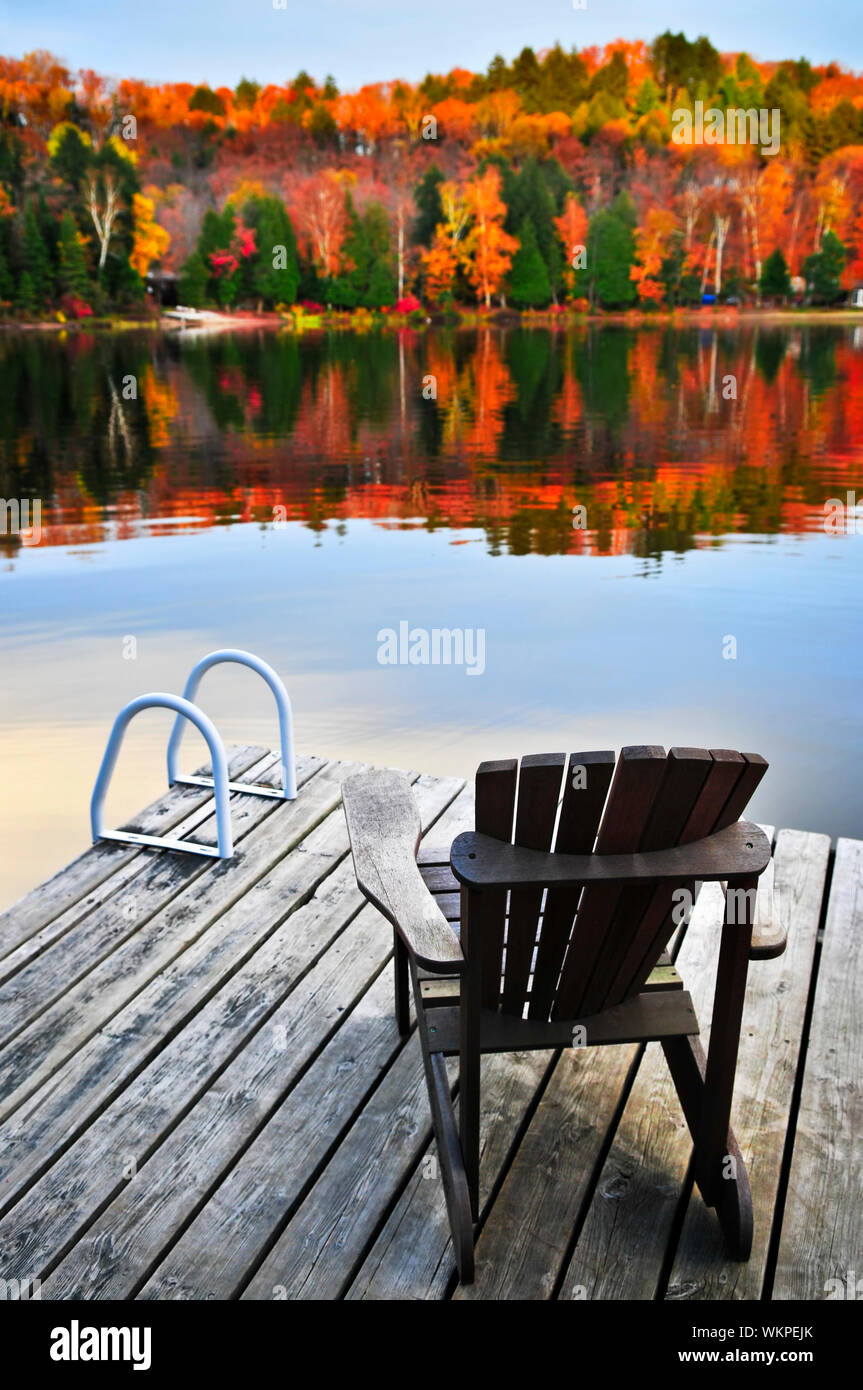 Wooden dock with chair on calm fall lake Stock Photo - Alamy