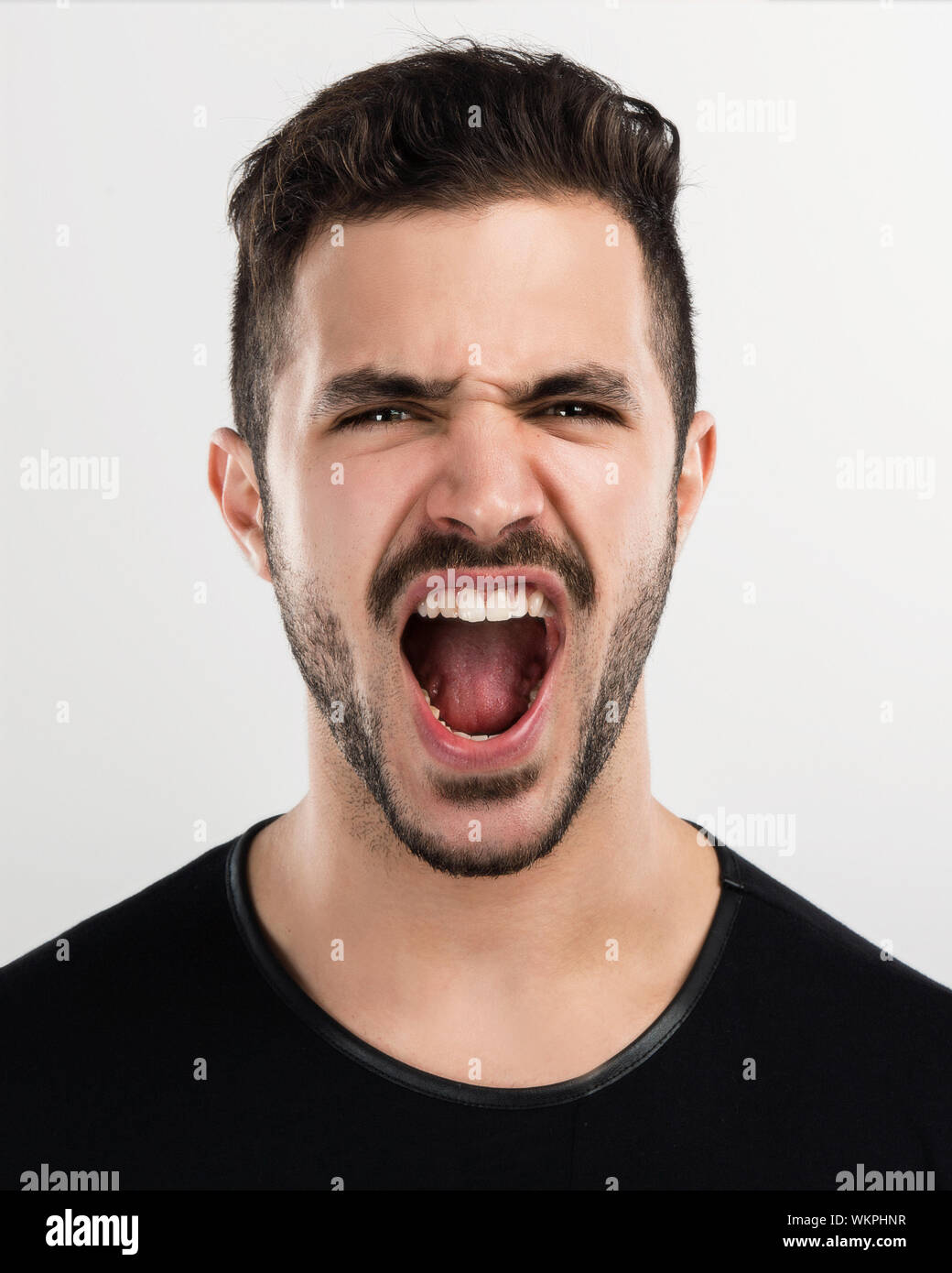 Studio portrait of a handsome young man yelling Stock Photo - Alamy