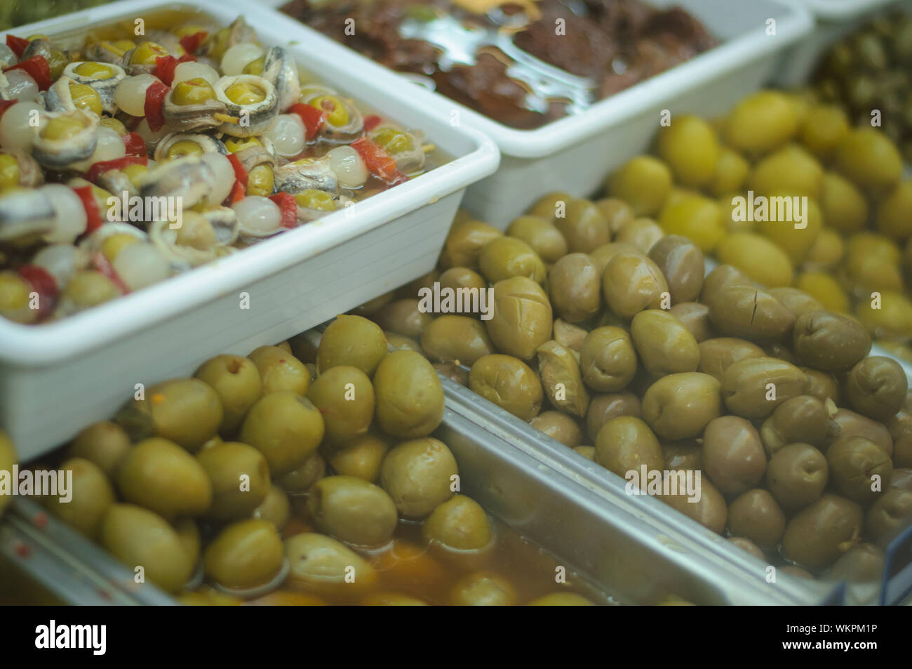 traditional Spanish green marinated olives on trays on the market ...