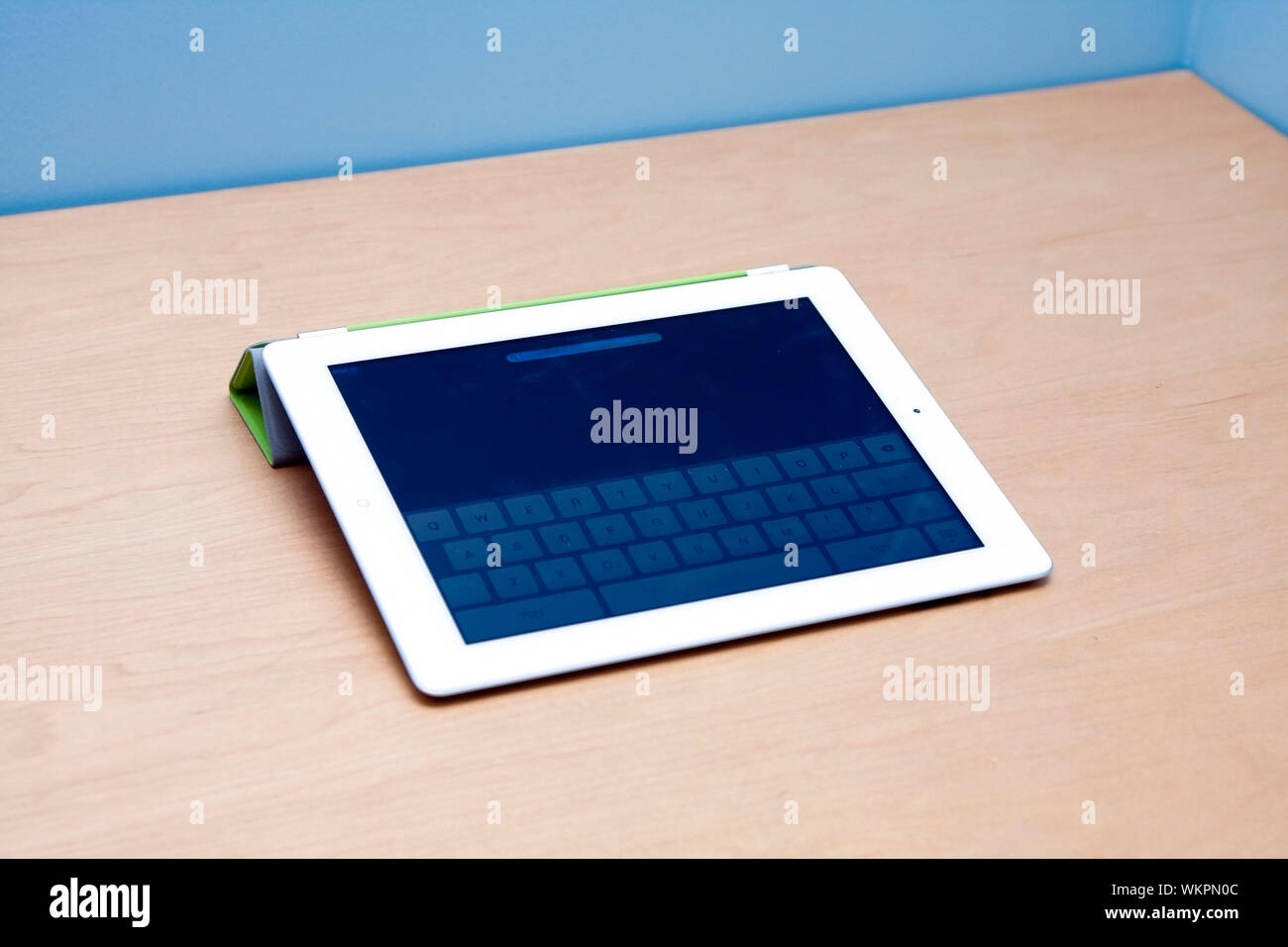 The new iPad 2 from Mac Apple, on a wooden desk and blue background ...