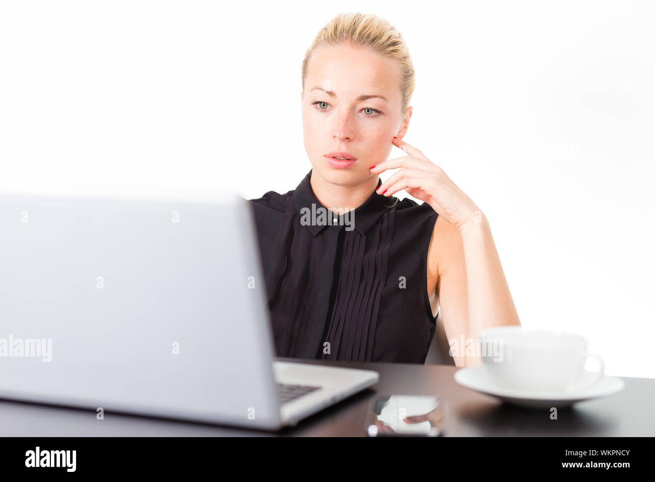 Business woman checking some information on her laptop computer in ...