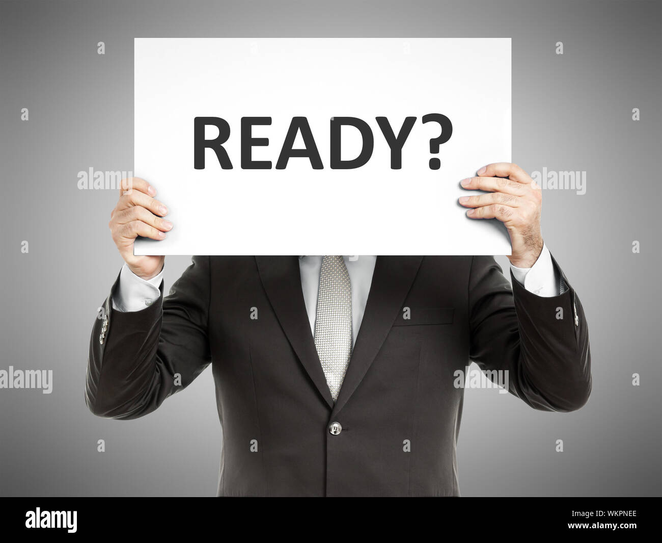 A business man holding a paper in front of his face with the text ready ...
