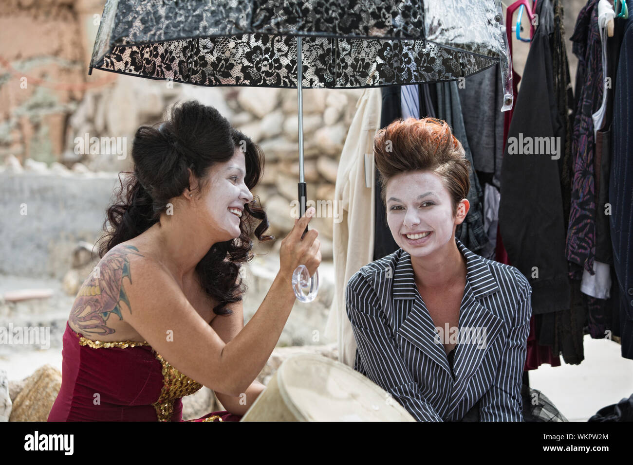 Two female cirque clowns with umbrella outdoors Stock Photo - Alamy