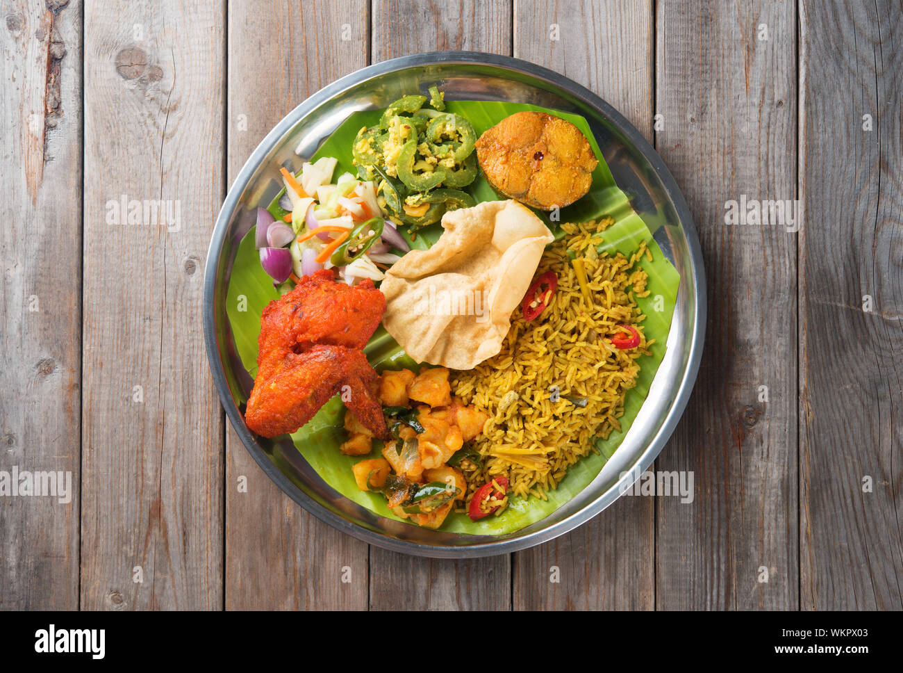 Overhead view of full length Indian biryani rice on wooden dining table ...