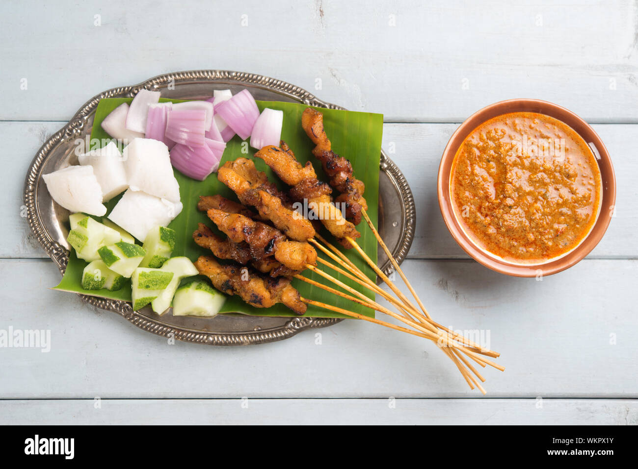 Fresh chicken satay on wooden dining table, one of famous Malaysian ...