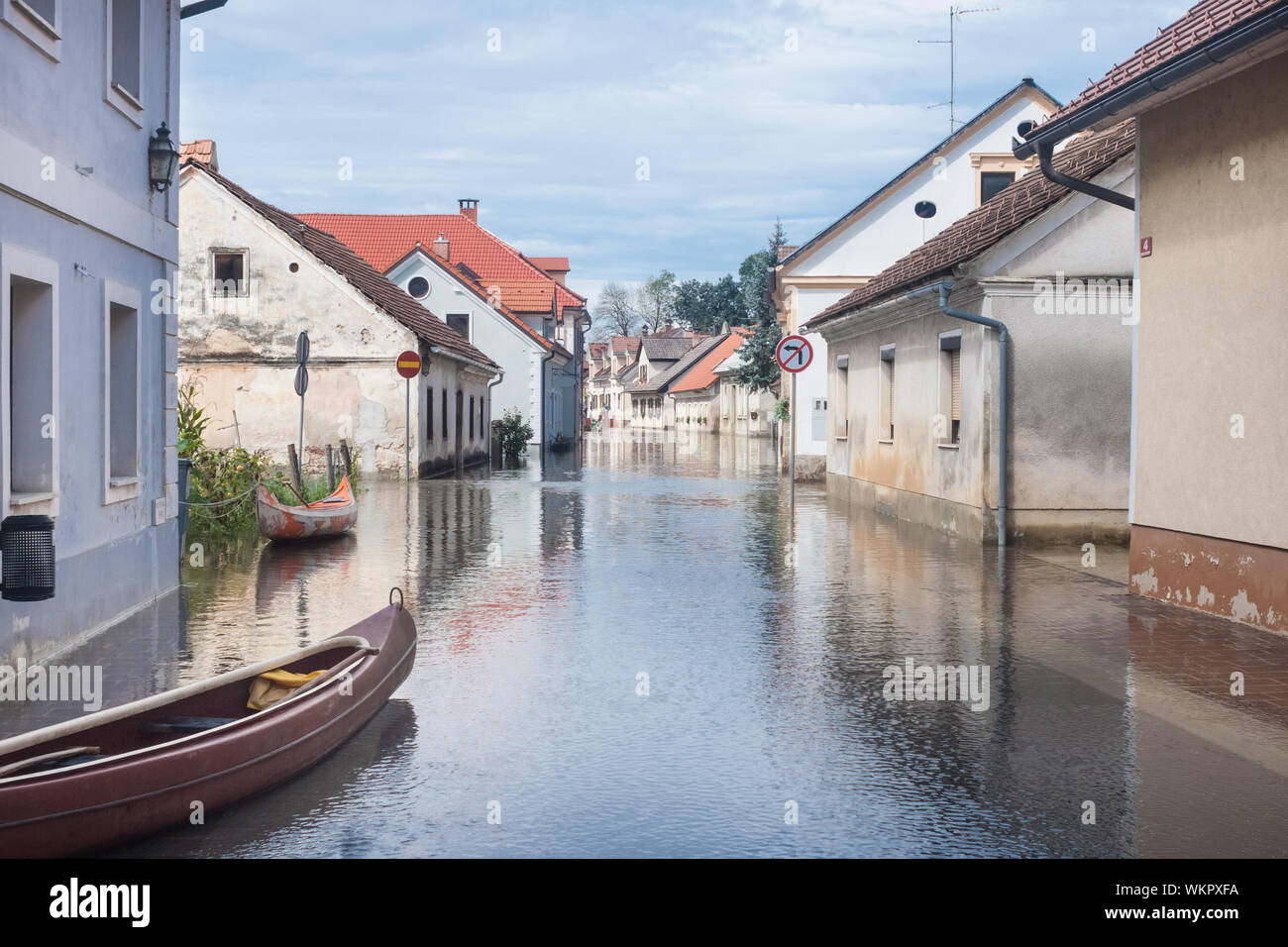 Rural village houses in floodwater. Road with the river overflown with ...