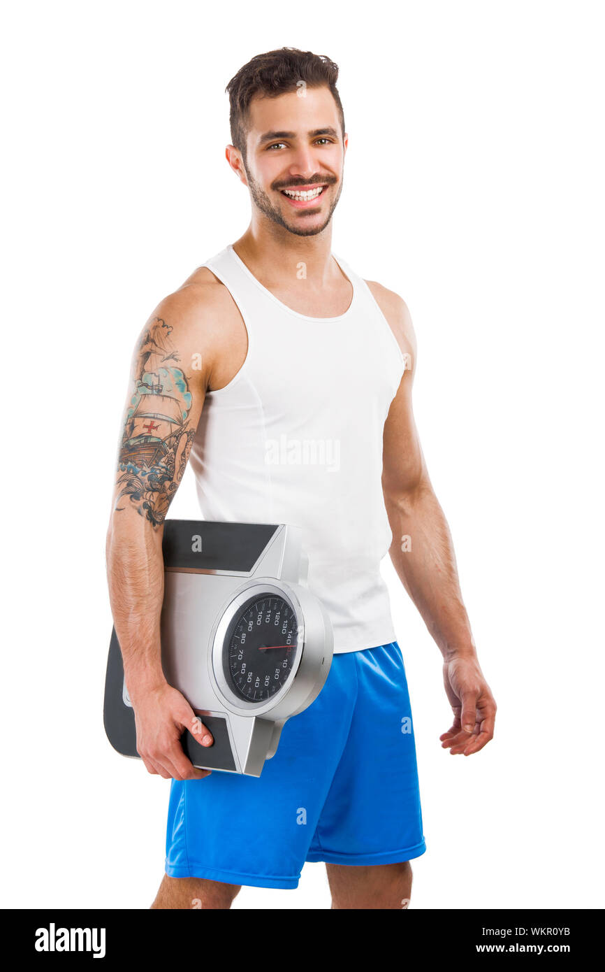Athletic young man holding a scale and smile to the camera, isolated ...