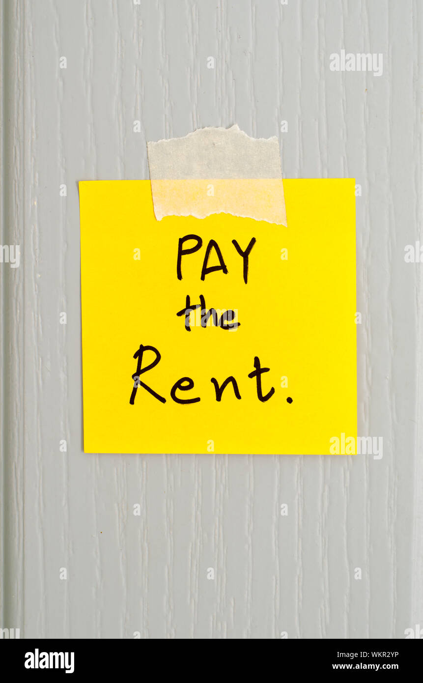 sticky note write a message pay the rent on wood door background Stock ...