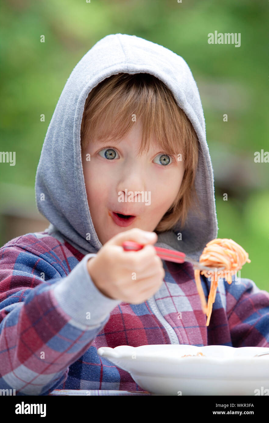 Boy with Blond Hair in Hood Eating Pasta Stock Photo - Alamy