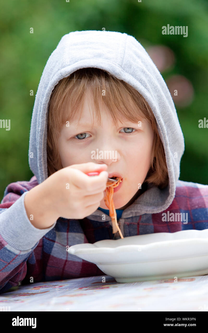 Boy with Blond Hair in Hood Eating Pasta Stock Photo - Alamy