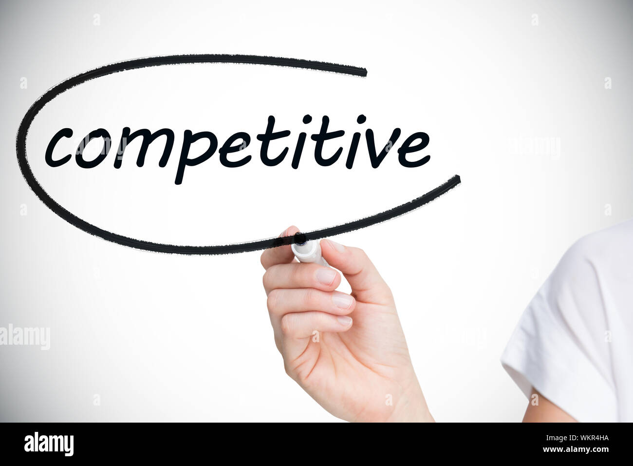 Businesswoman writing the word competitive against white background ...