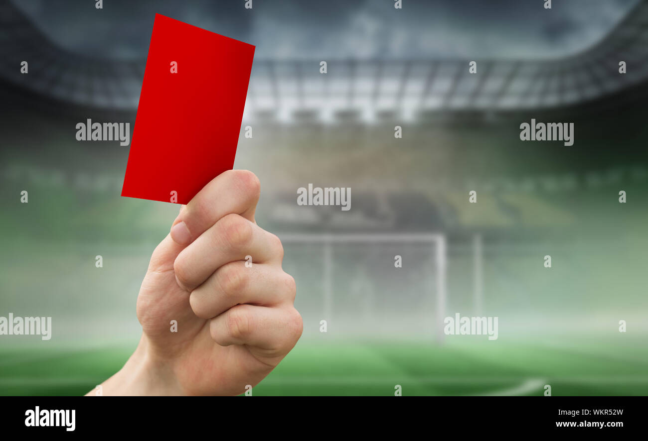 Hand holding up red card against football pitch in large stadium Stock ...