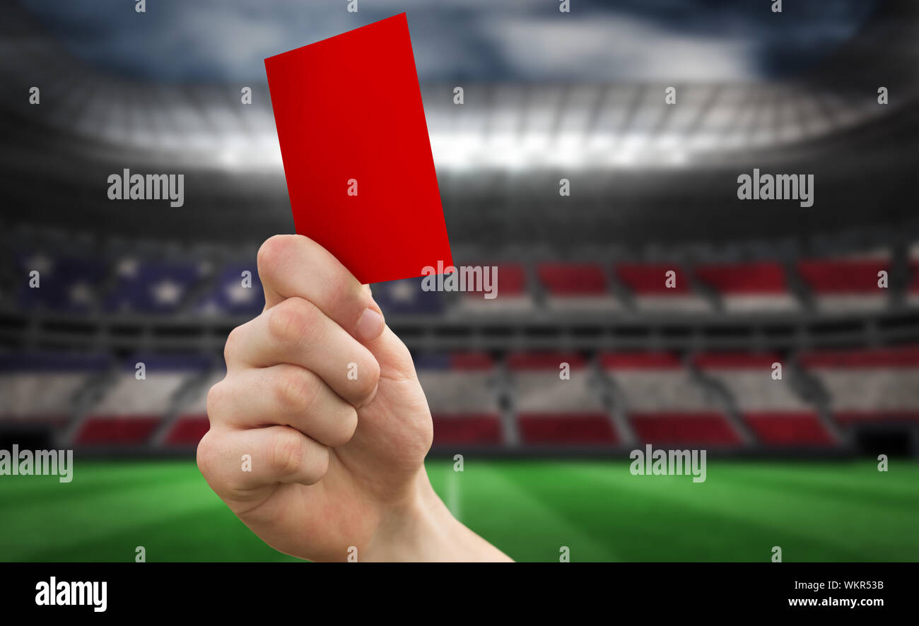 Hand holding up red card against stadium full of usa football fans ...