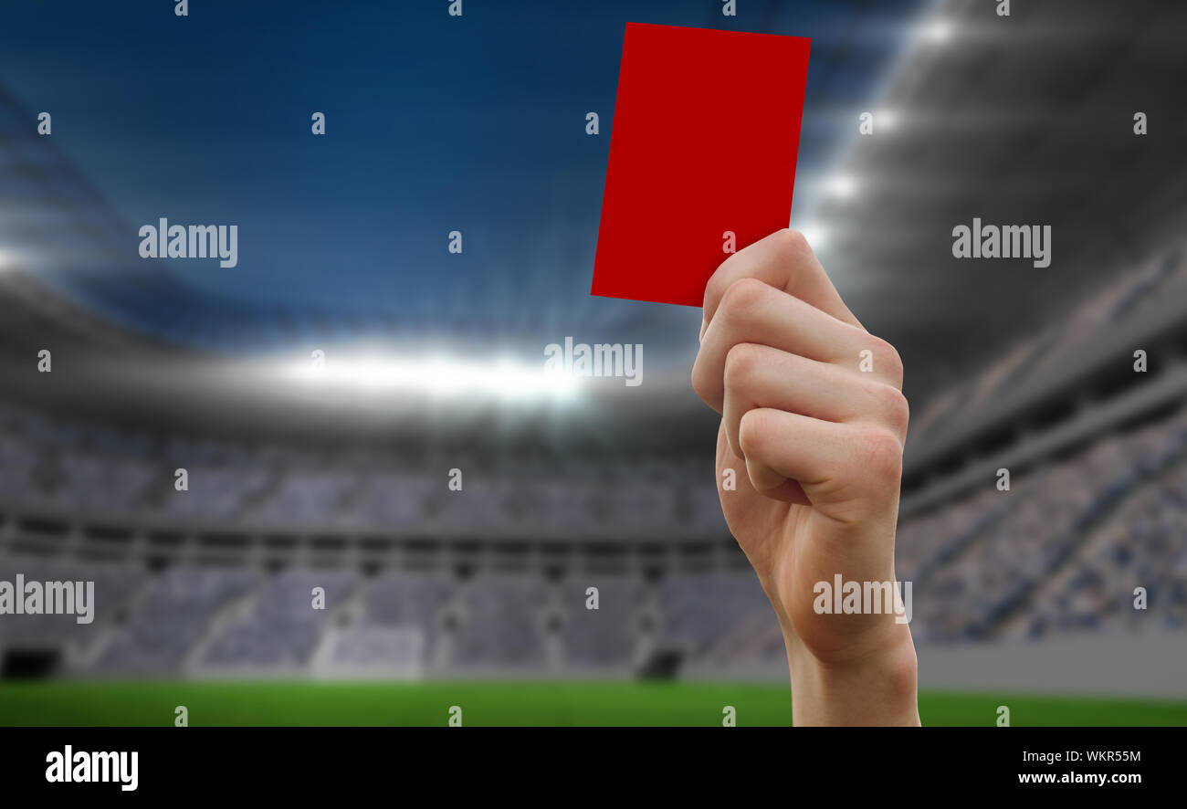 Hand holding up red card against football stadium Stock Photo - Alamy