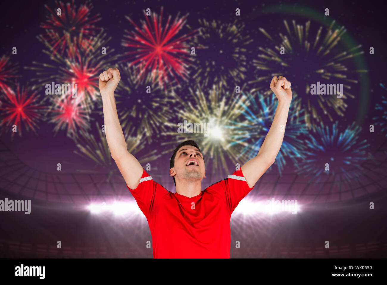 Excited football player cheering against fireworks exploding over ...