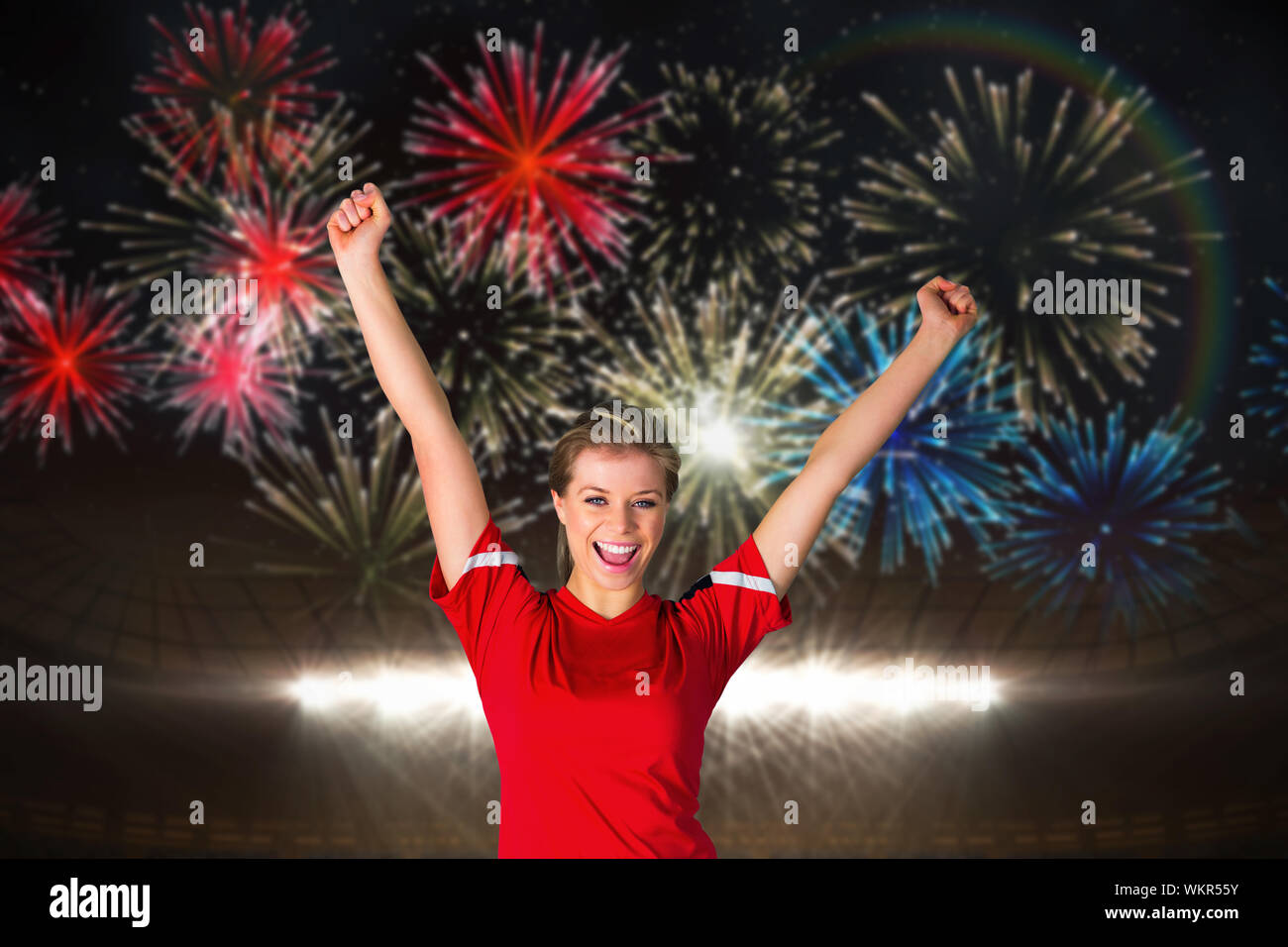 Cheering football fan in red against fireworks exploding over football ...