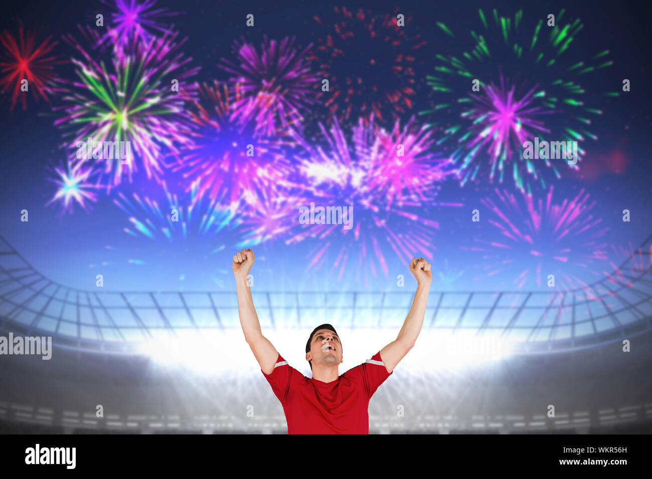 Excited football player cheering against fireworks exploding over ...
