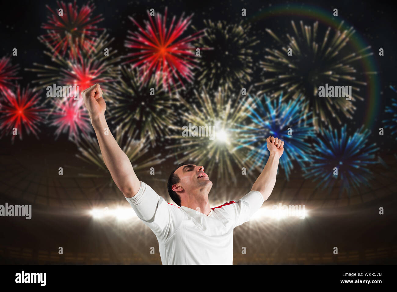 Excited football fan cheering against fireworks exploding over football ...
