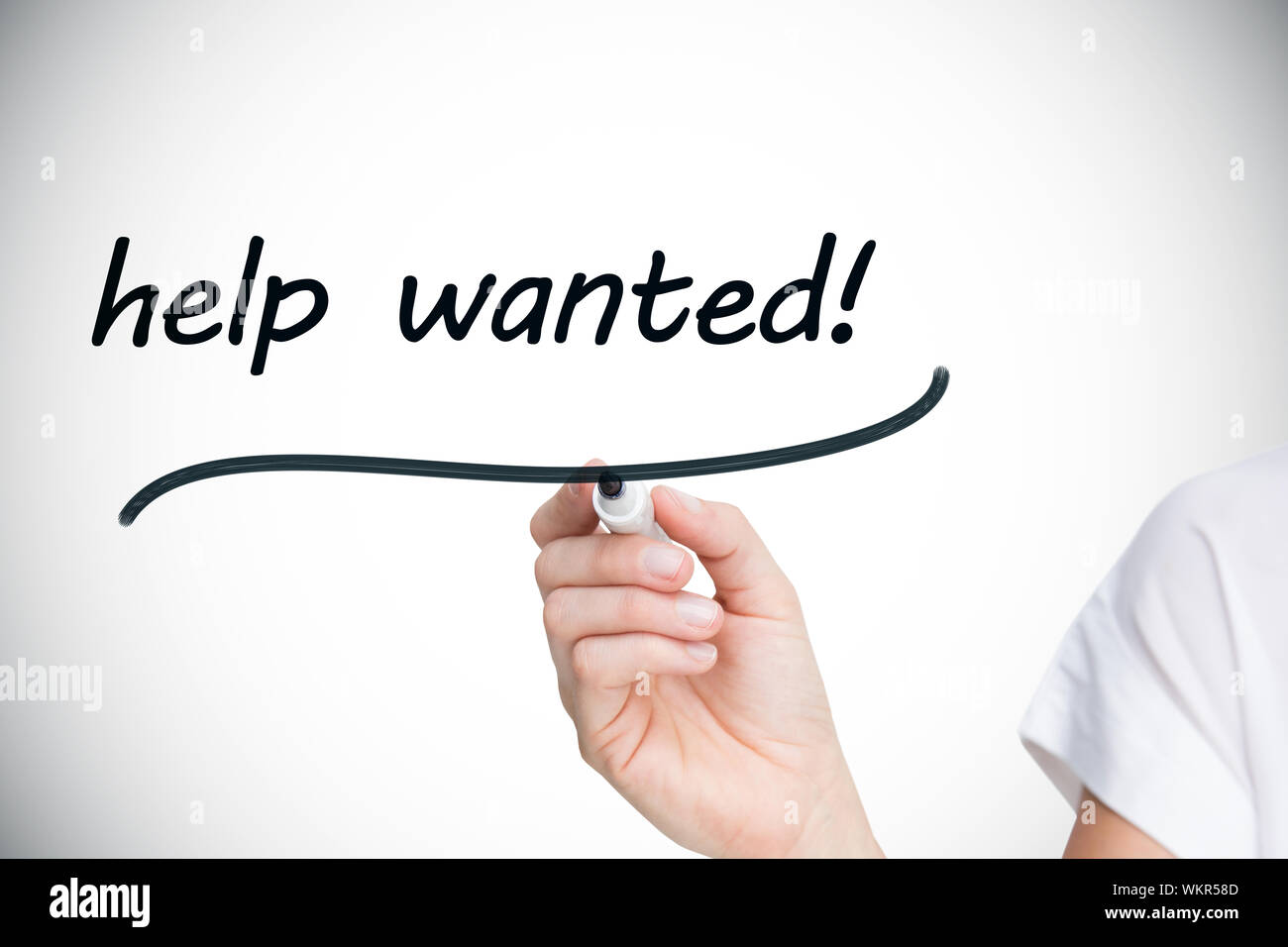 Businesswoman writing the words help wanted against white background ...