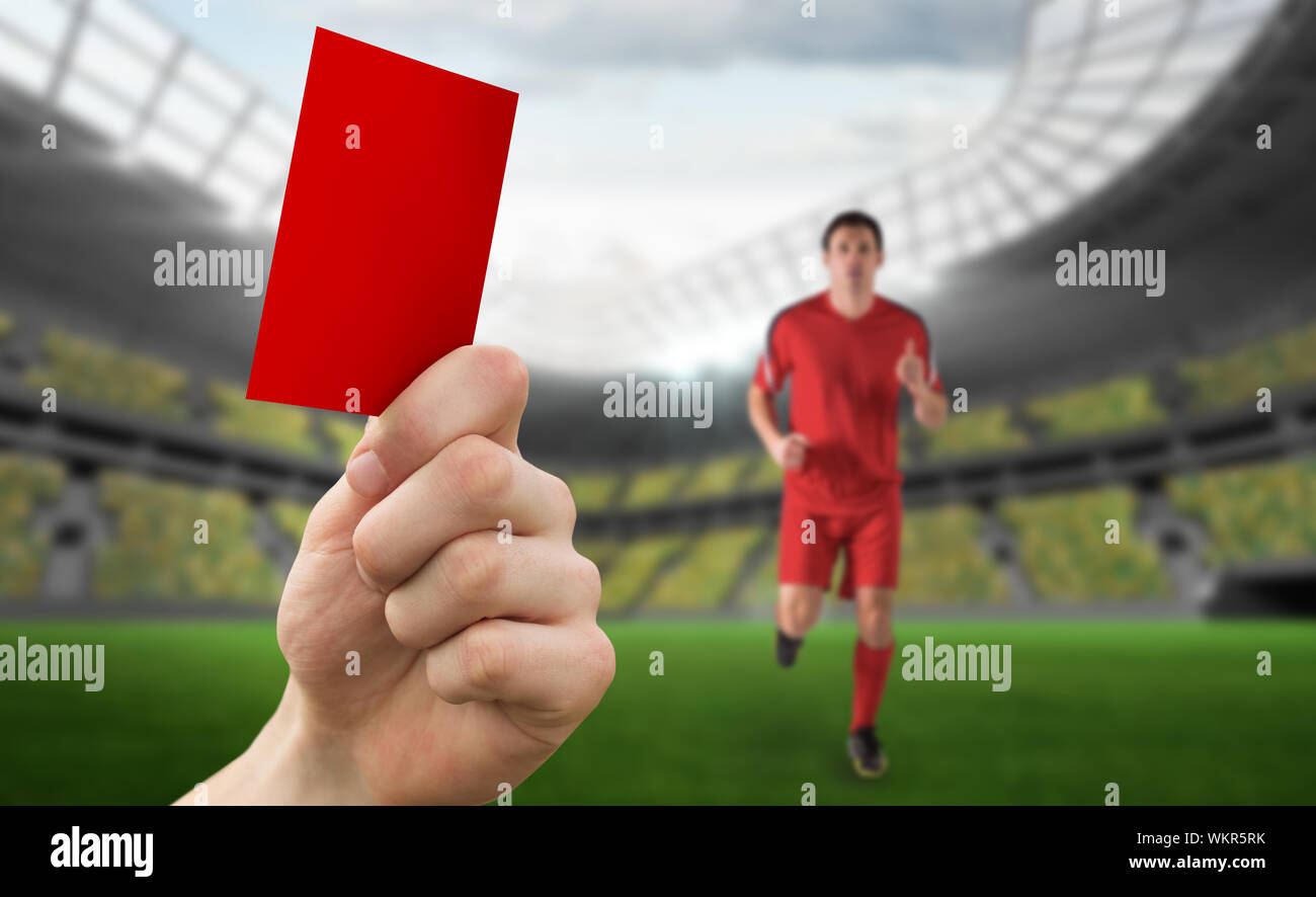 Hand holding up red card against football stadium and player Stock ...