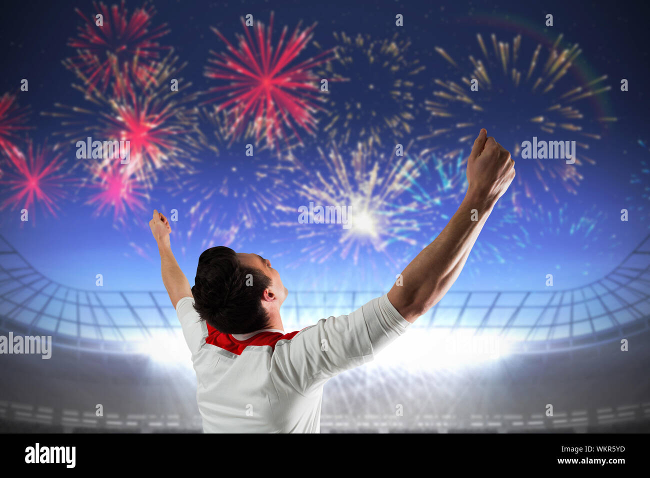 Excited football fan cheering against fireworks exploding over football ...