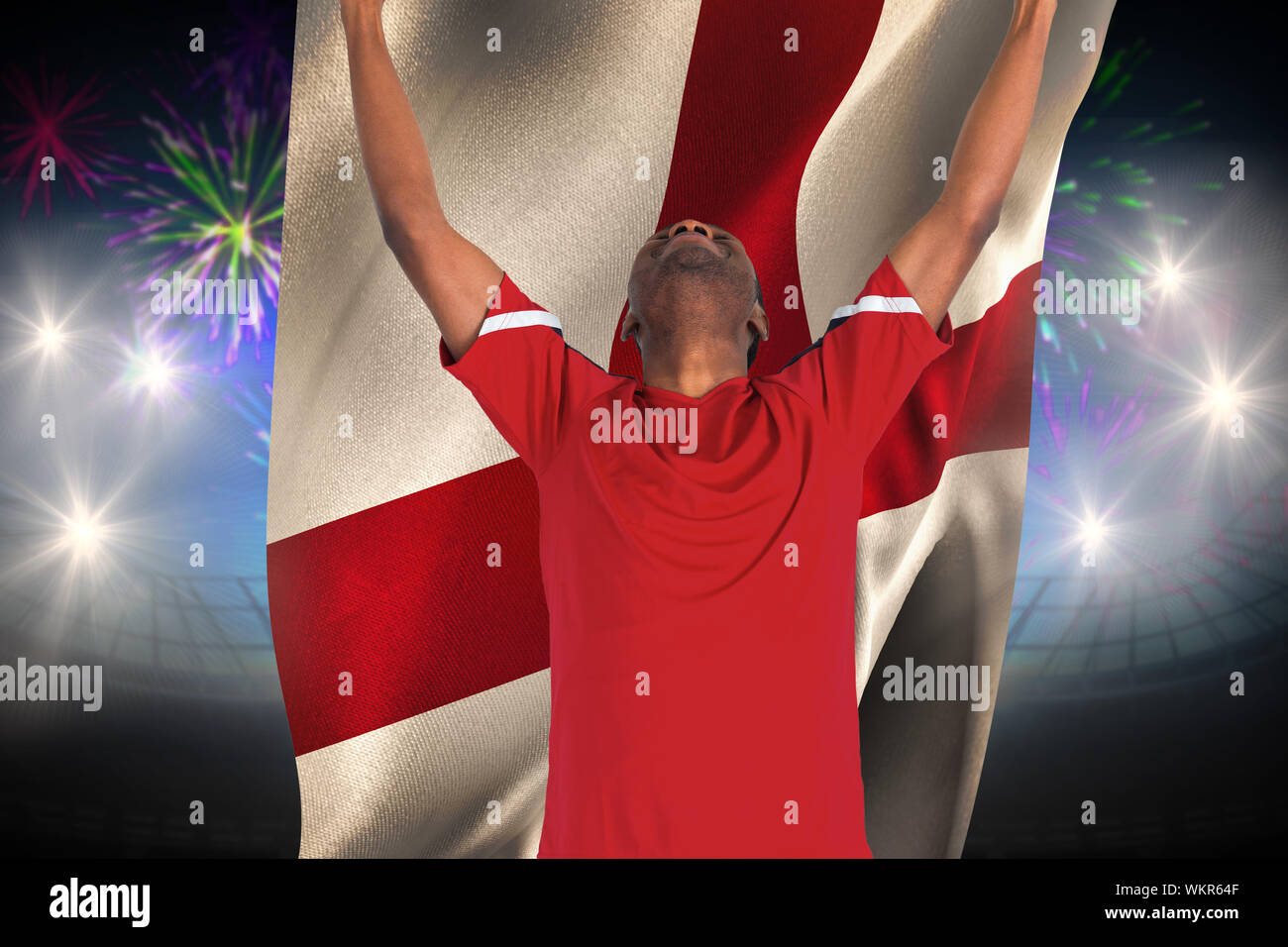 Excited handsome football fan cheering against fireworks exploding over ...