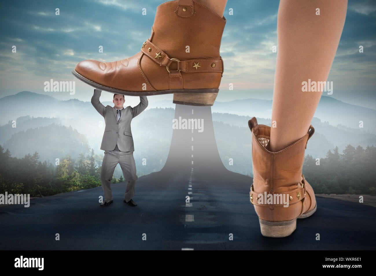 Composite image of cowboy boots stepping on businessman against road ...