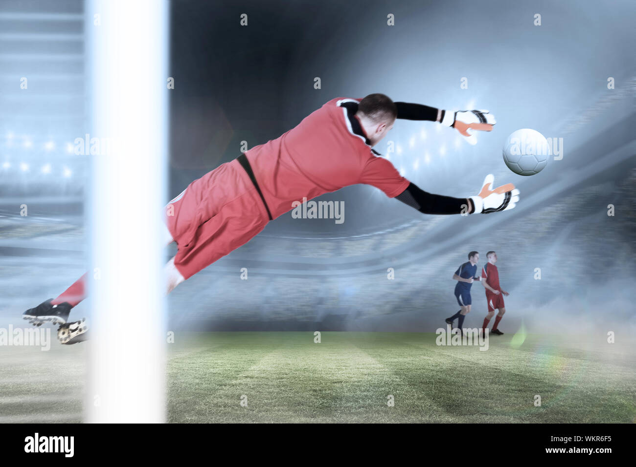 Fit goal keeper jumping up against football stadium Stock Photo - Alamy