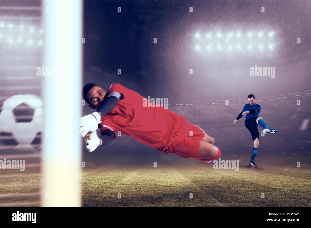 Goalkeeper in red making a save against large football stadium under ...