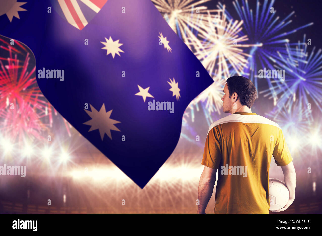 Football player in yellow holding ball against fireworks exploding over ...