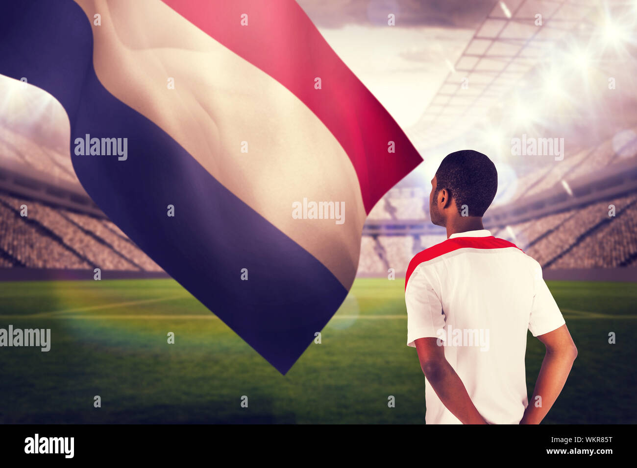 Football fan in white standing against large football stadium with ...