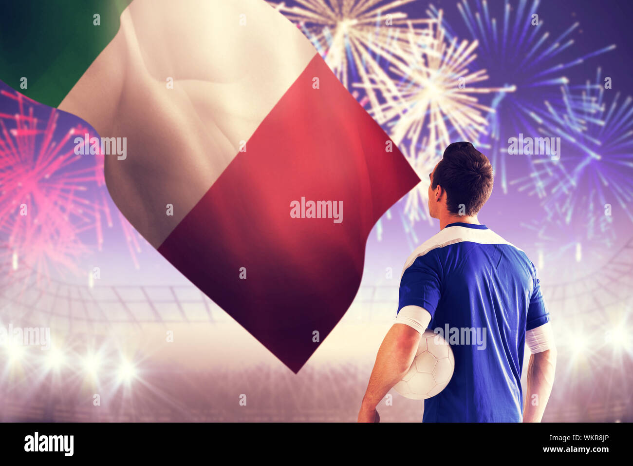 Handsome italian football player in blue jersey against fireworks ...