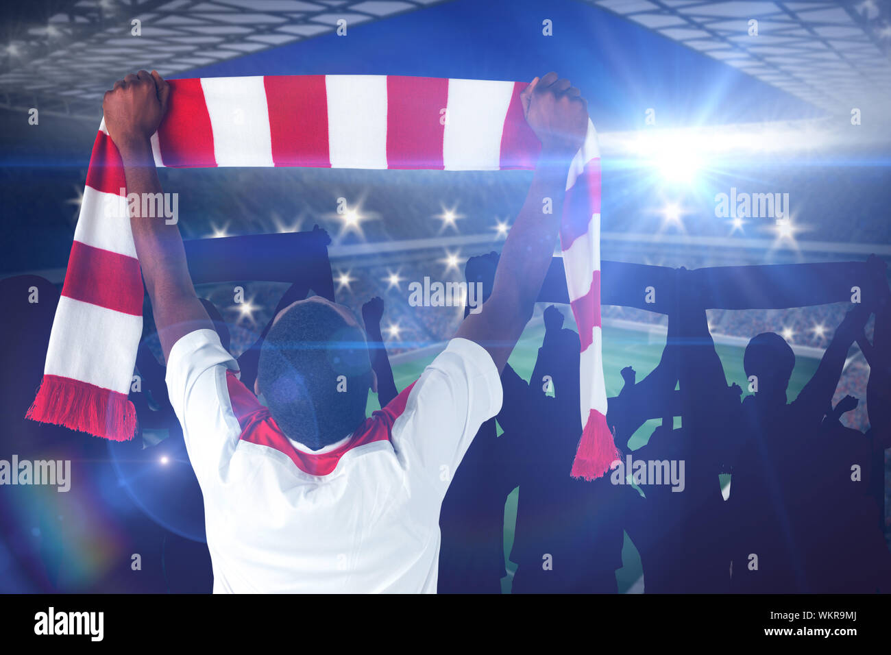 Happy football fan waving scarf against large football stadium with ...