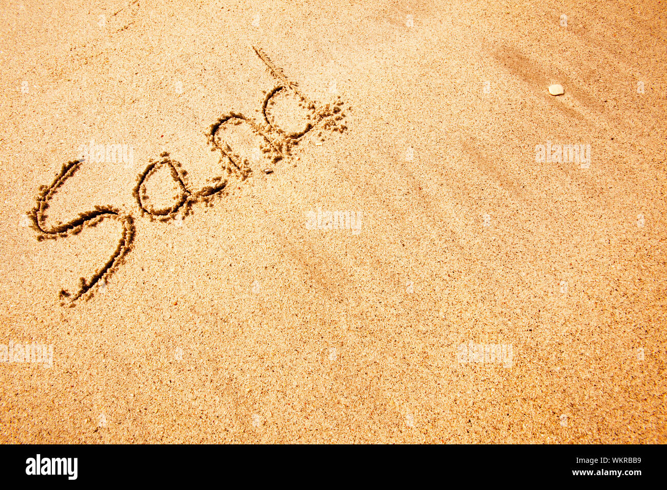 The word sand written in the sand at a beach - background texture Stock ...