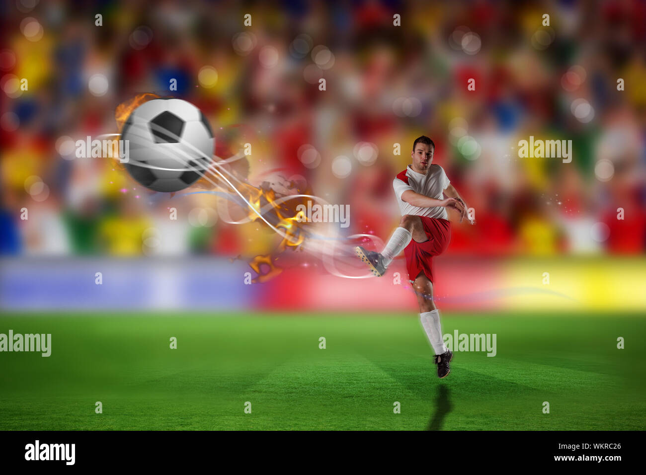 Football player in white kicking against blurry football pitch with ...