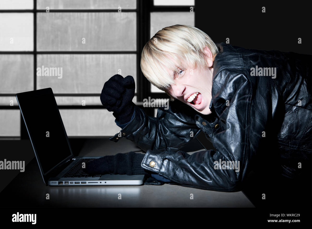 Computer criminal hacking on a laptop in secret location Stock Photo ...