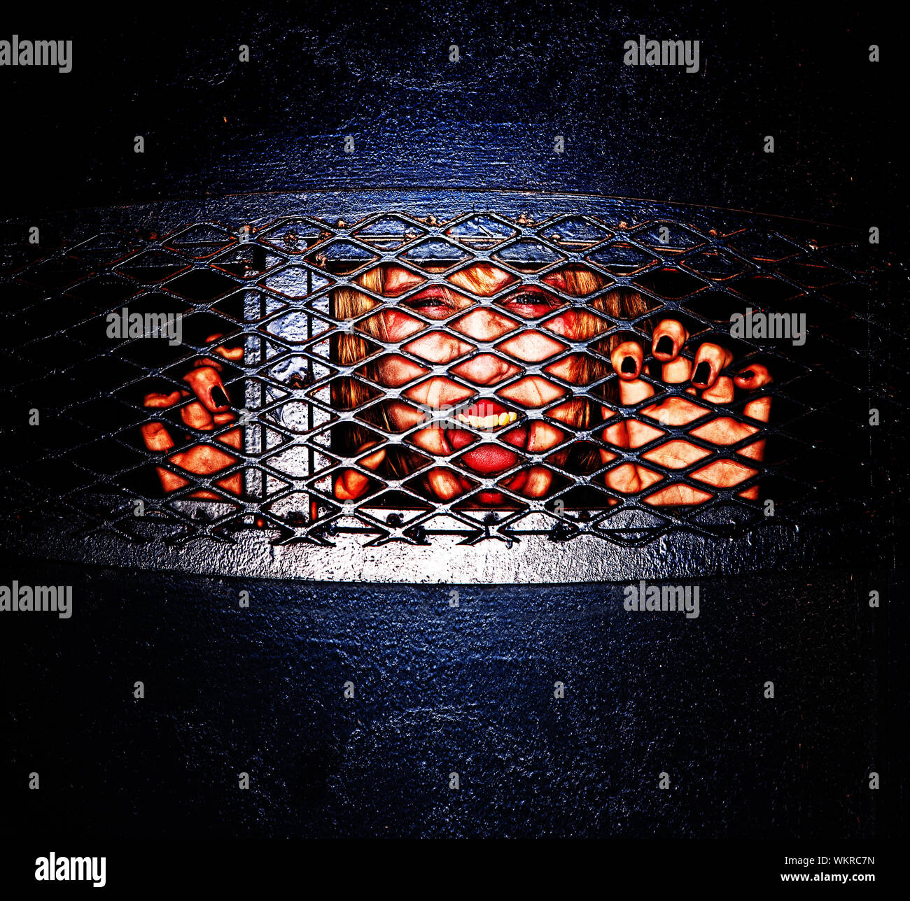 Young woman screaming behind a heavy metal grate Stock Photo - Alamy