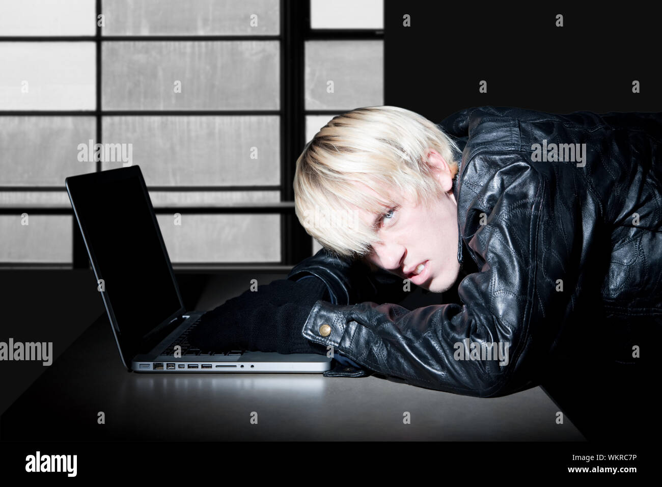 Computer criminal hacking on a laptop in secret location Stock Photo ...