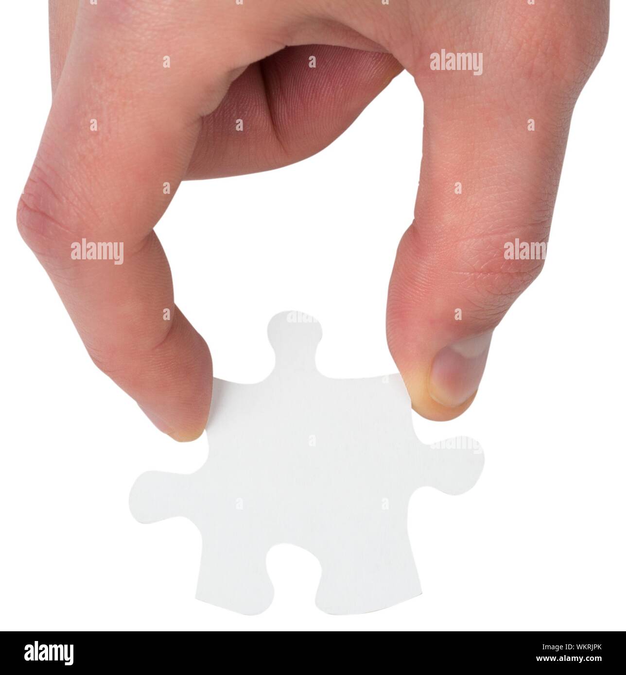 Hand holding jigsaw piece on white background Stock Photo - Alamy