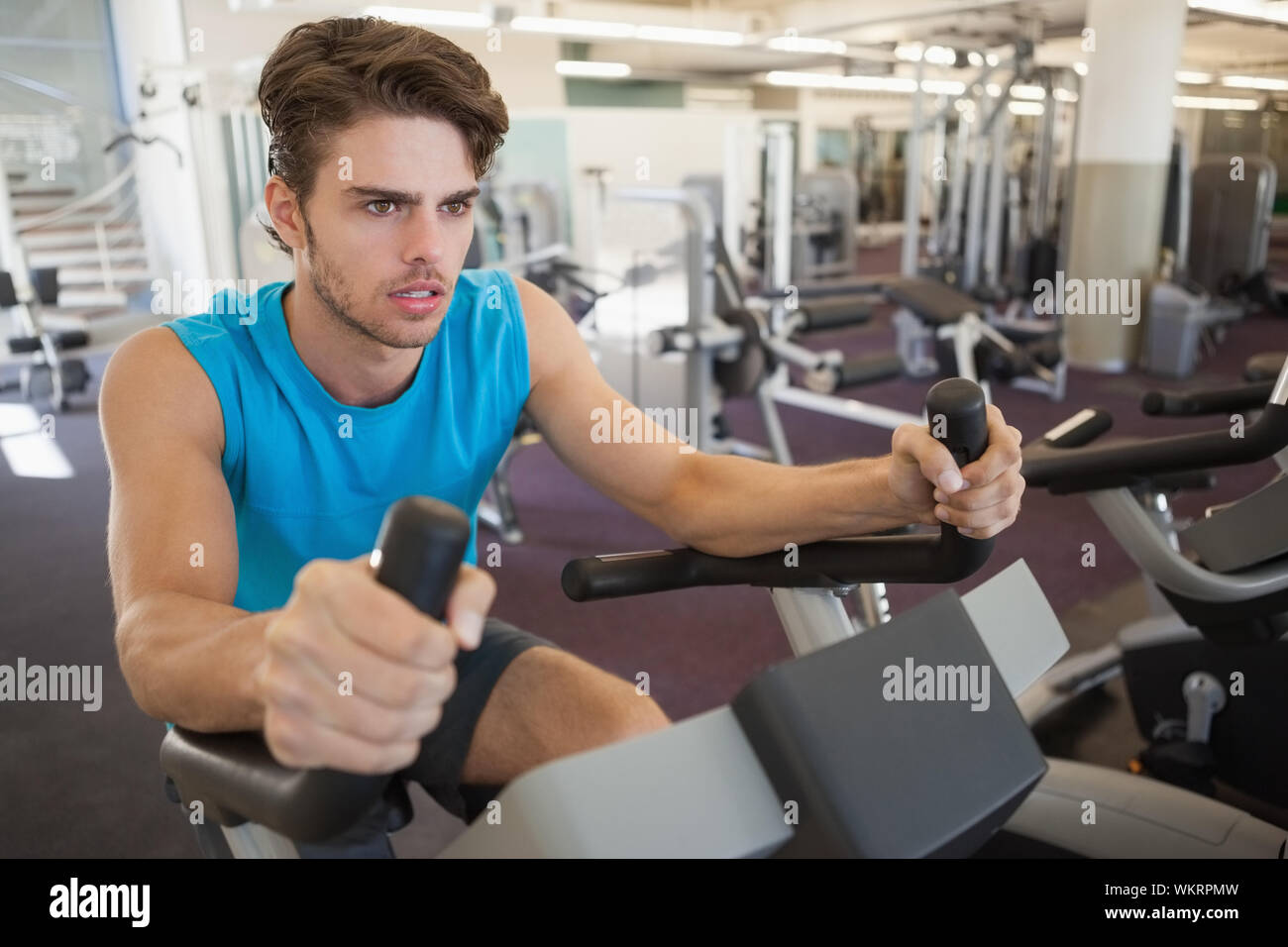 Focused fit man on the exercise bike at the gym Stock Photo - Alamy