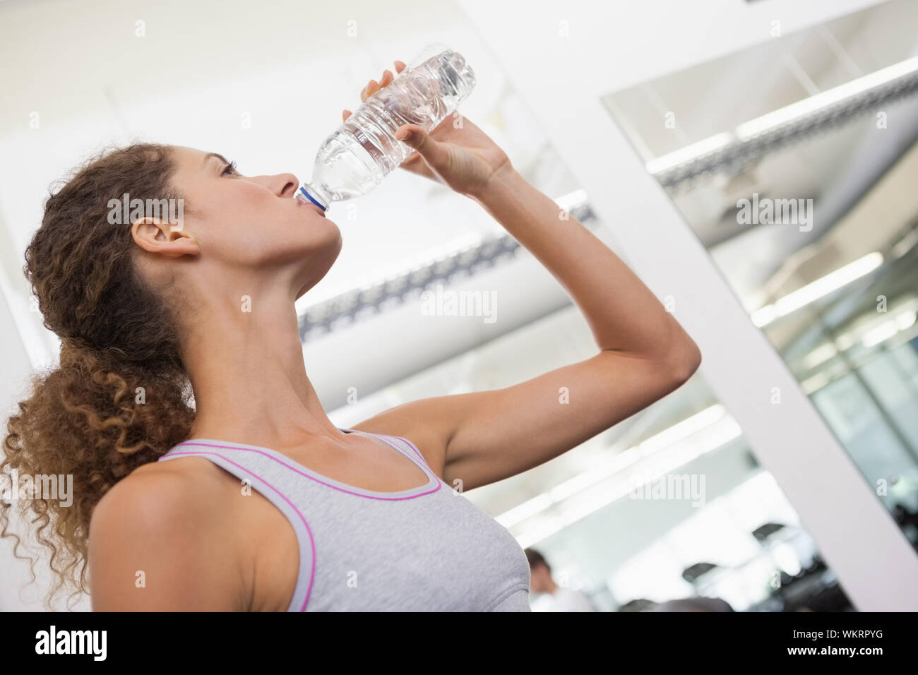 Fit woman drinking from water bottle at the gym Stock Photo - Alamy