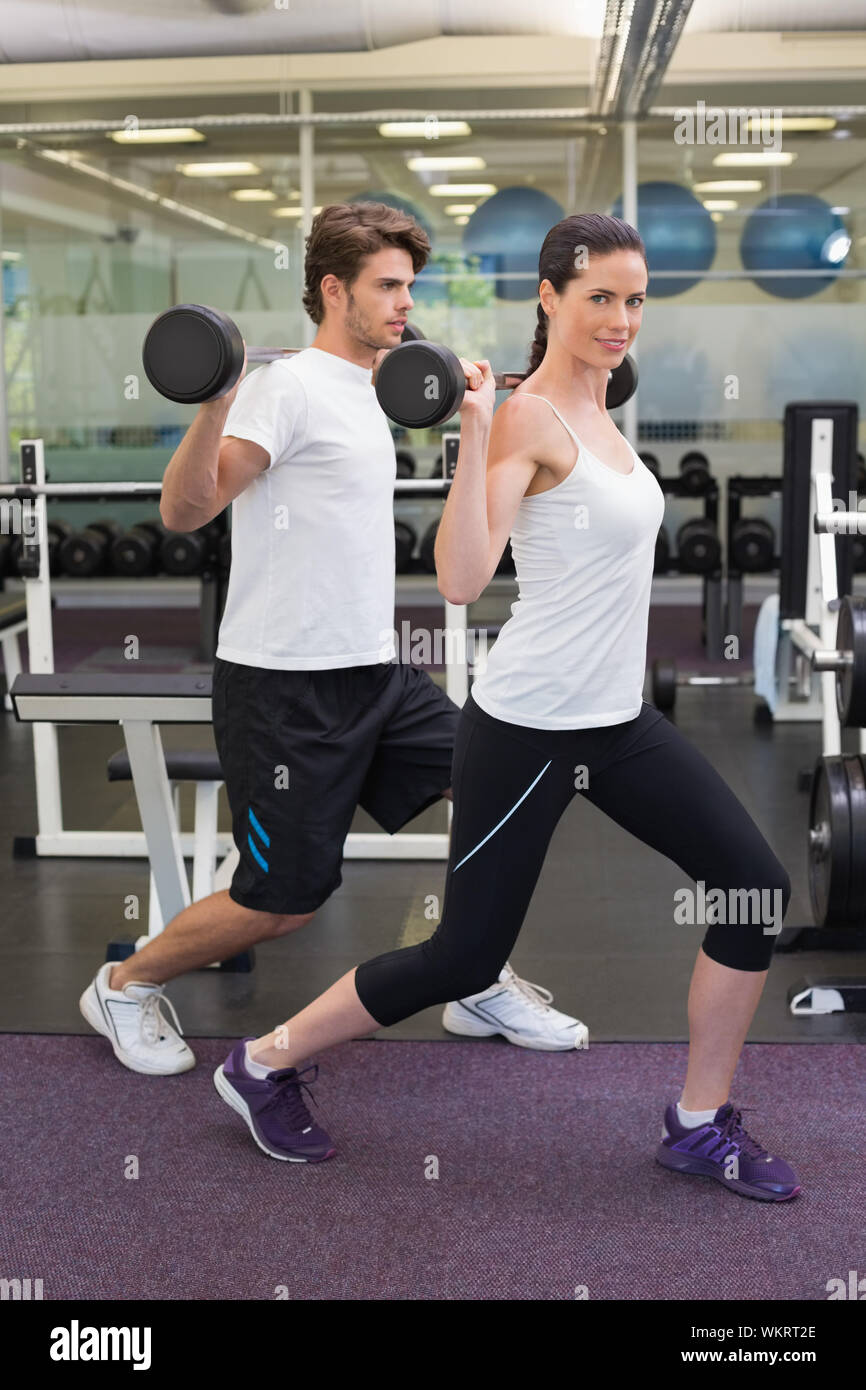 Fit couple lifting barbells together at the gym Stock Photo - Alamy